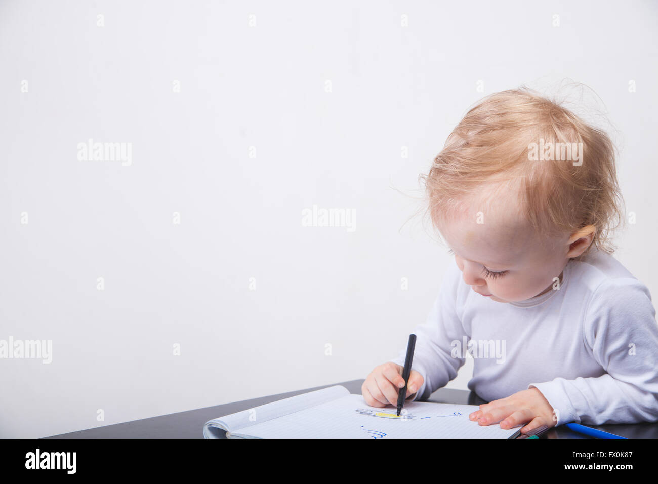 Baby girl drawing with colorful felt-tip pens on white background Stock ...