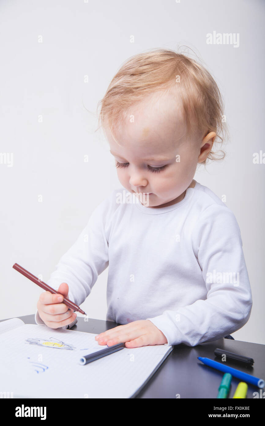 Baby girl drawing with colorful felt-tip pens on white background Stock ...