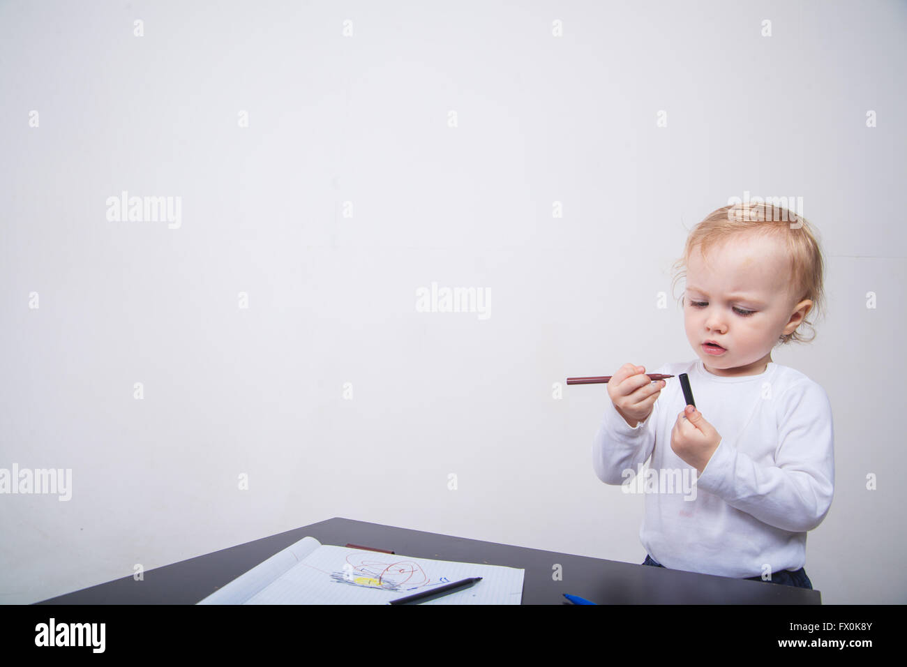 Baby girl drawing with colorful felt-tip pens on white background Stock ...