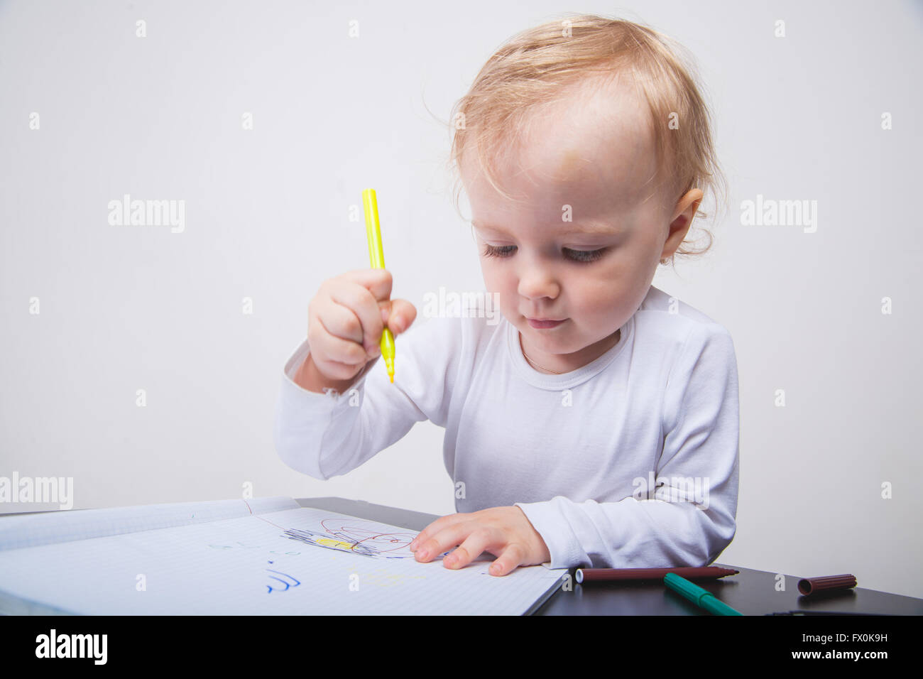 Baby girl drawing with colorful felt-tip pens on white background Stock ...