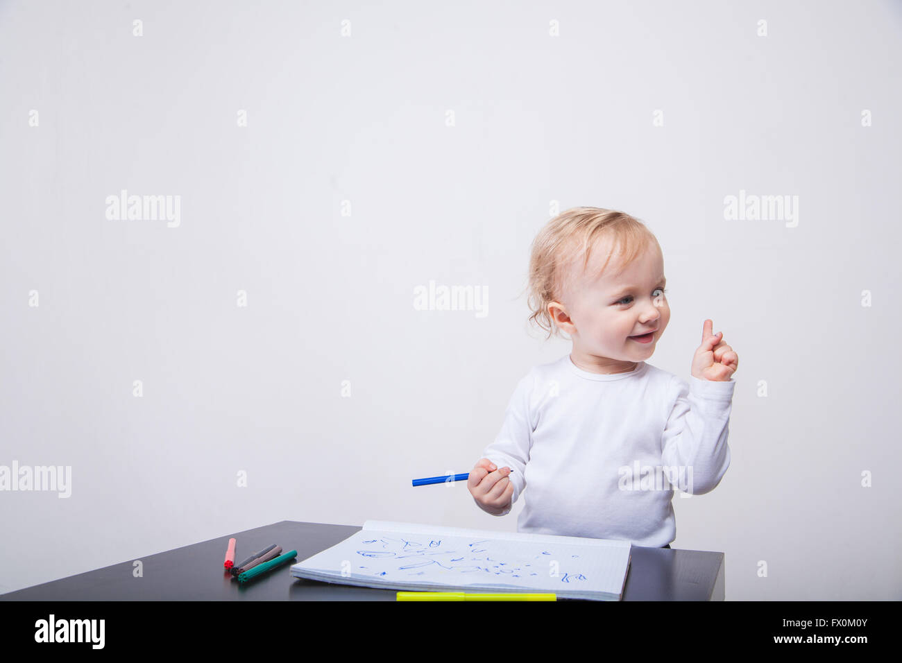 Baby girl drawing with colorful felt-tip pens on white background Stock ...