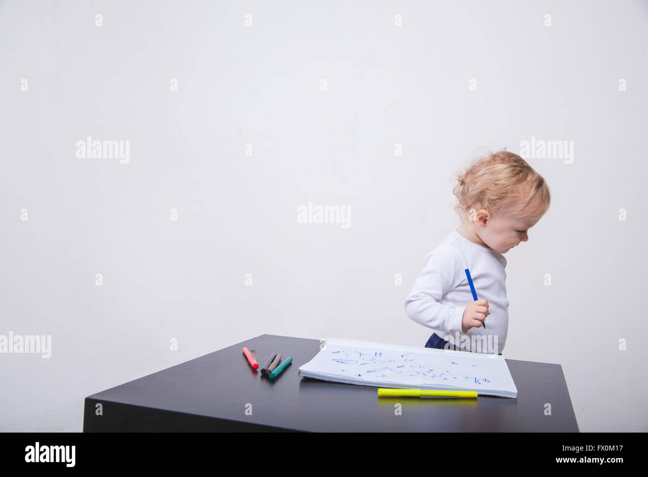 Baby girl drawing with colorful felt-tip pens on white background Stock ...
