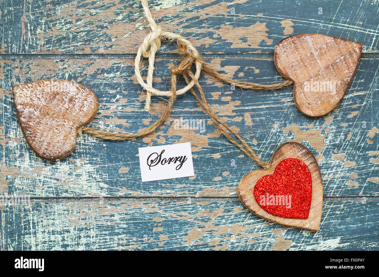 Sorry card with three wooden hearts on rustic surface Stock Photo - Alamy