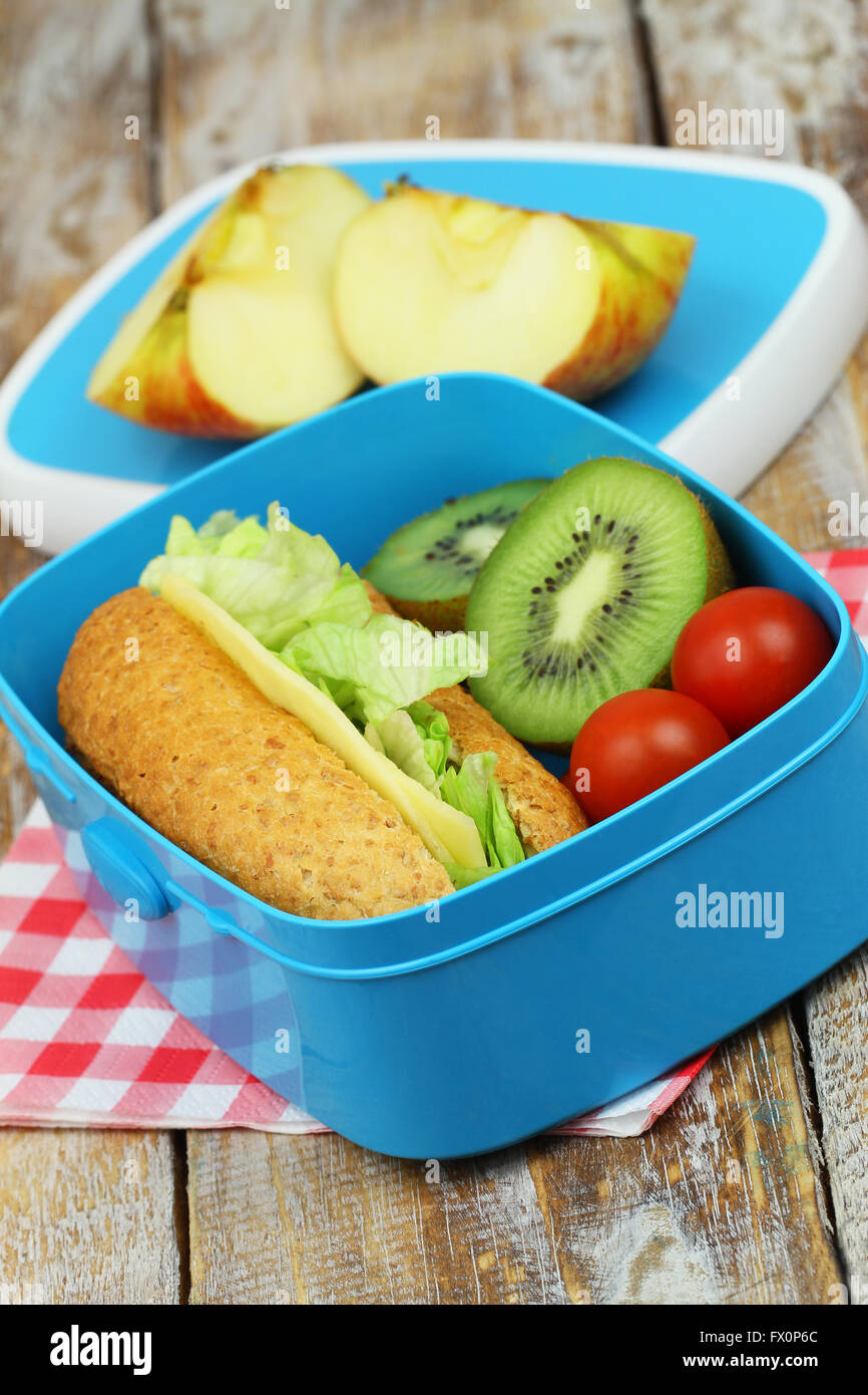 Healthy lunch box containing whole grain cheese sandwich, cherry ...