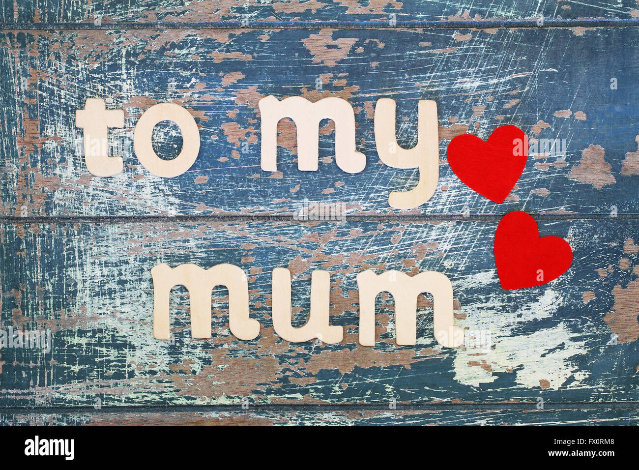To my mum written with wooden letters on rustic surface with two red ...