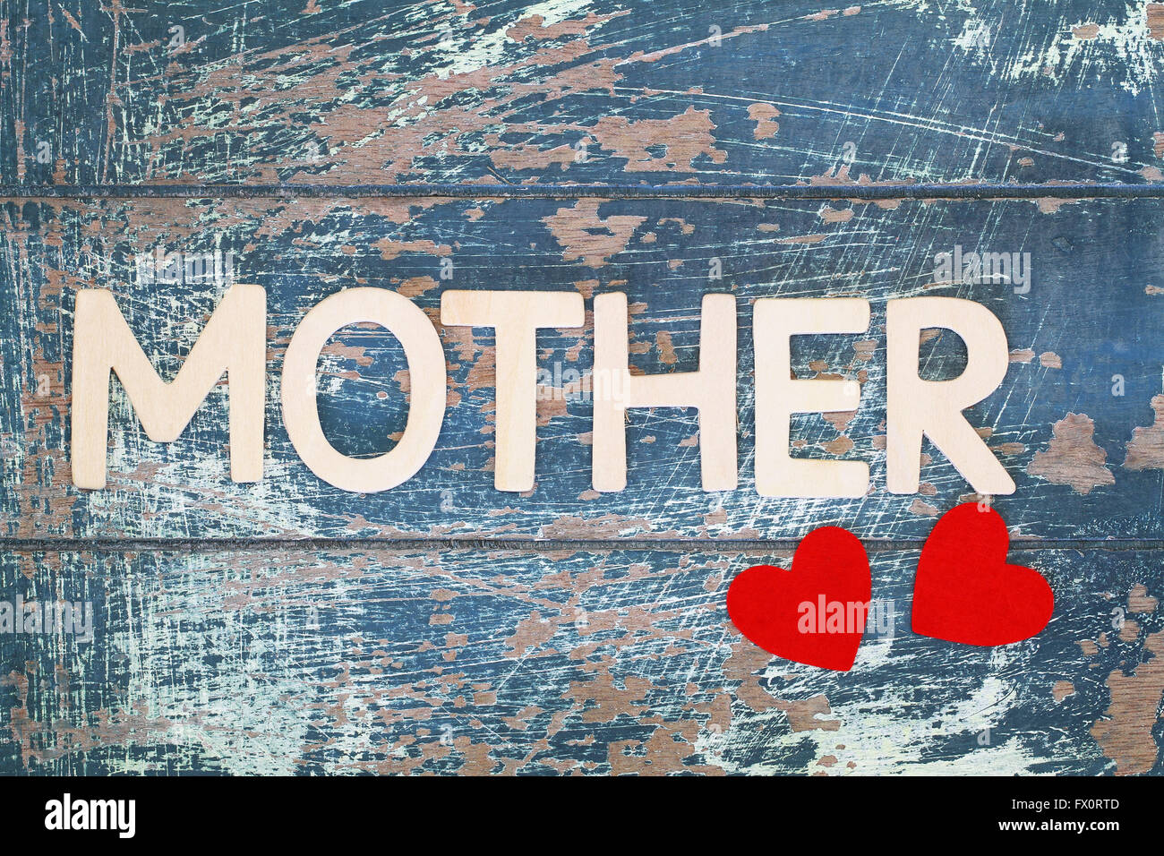 Word mother written with wooden letters on rustic surface with two red ...