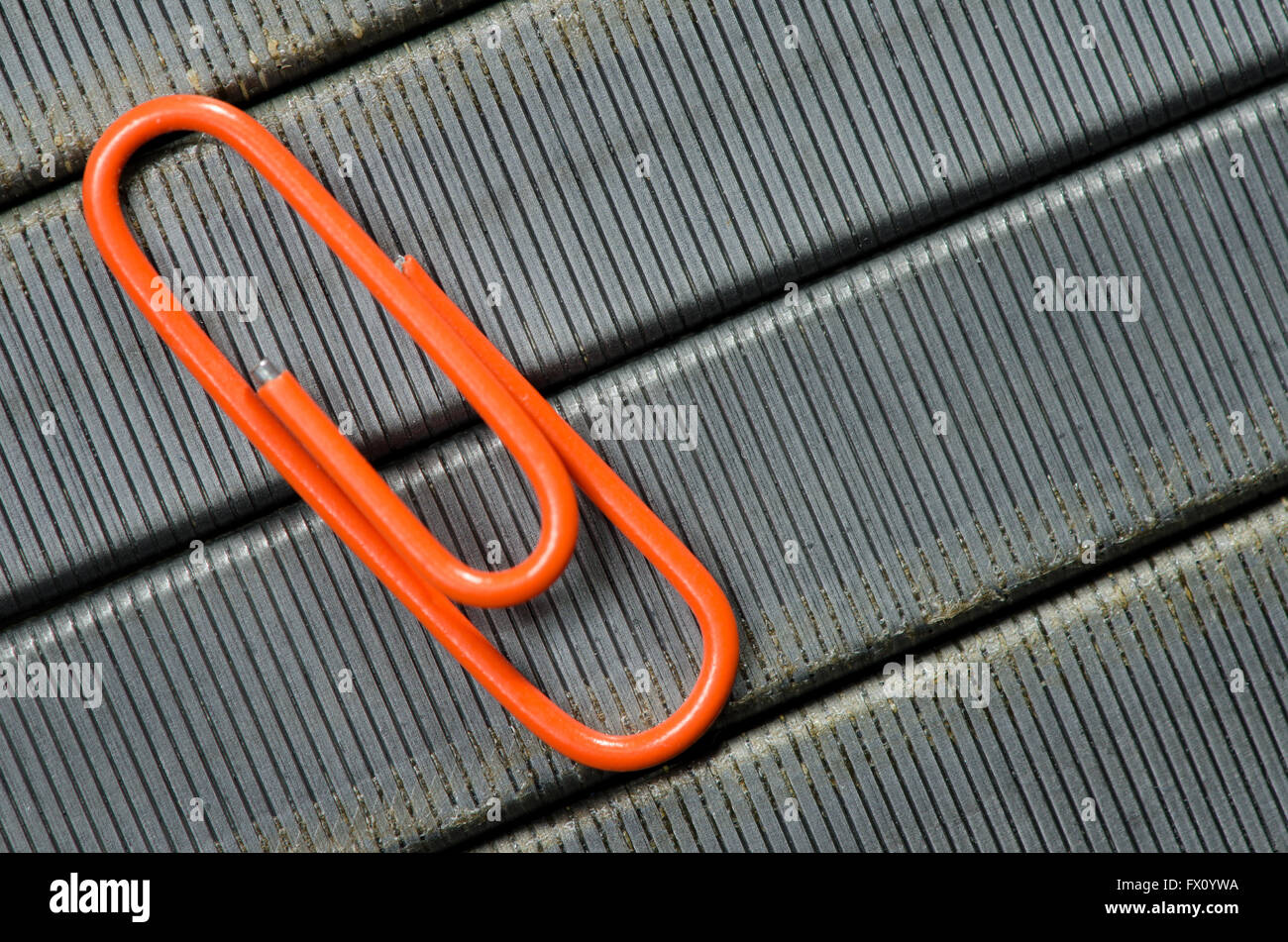 Orange paper clip on staple wire background as symbol of solitude Stock ...