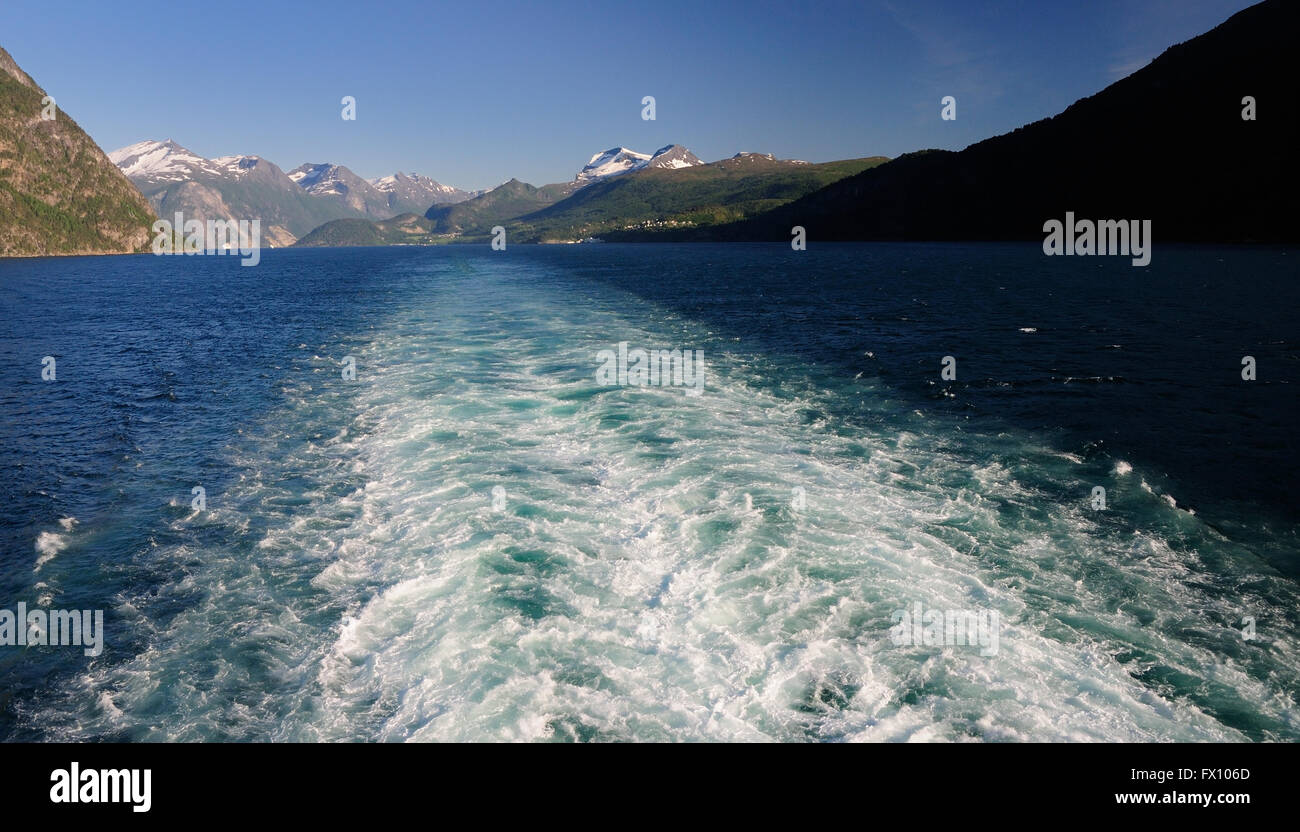 Wake of ship sailing along a Norwegian fjord in evening sunshine Stock ...