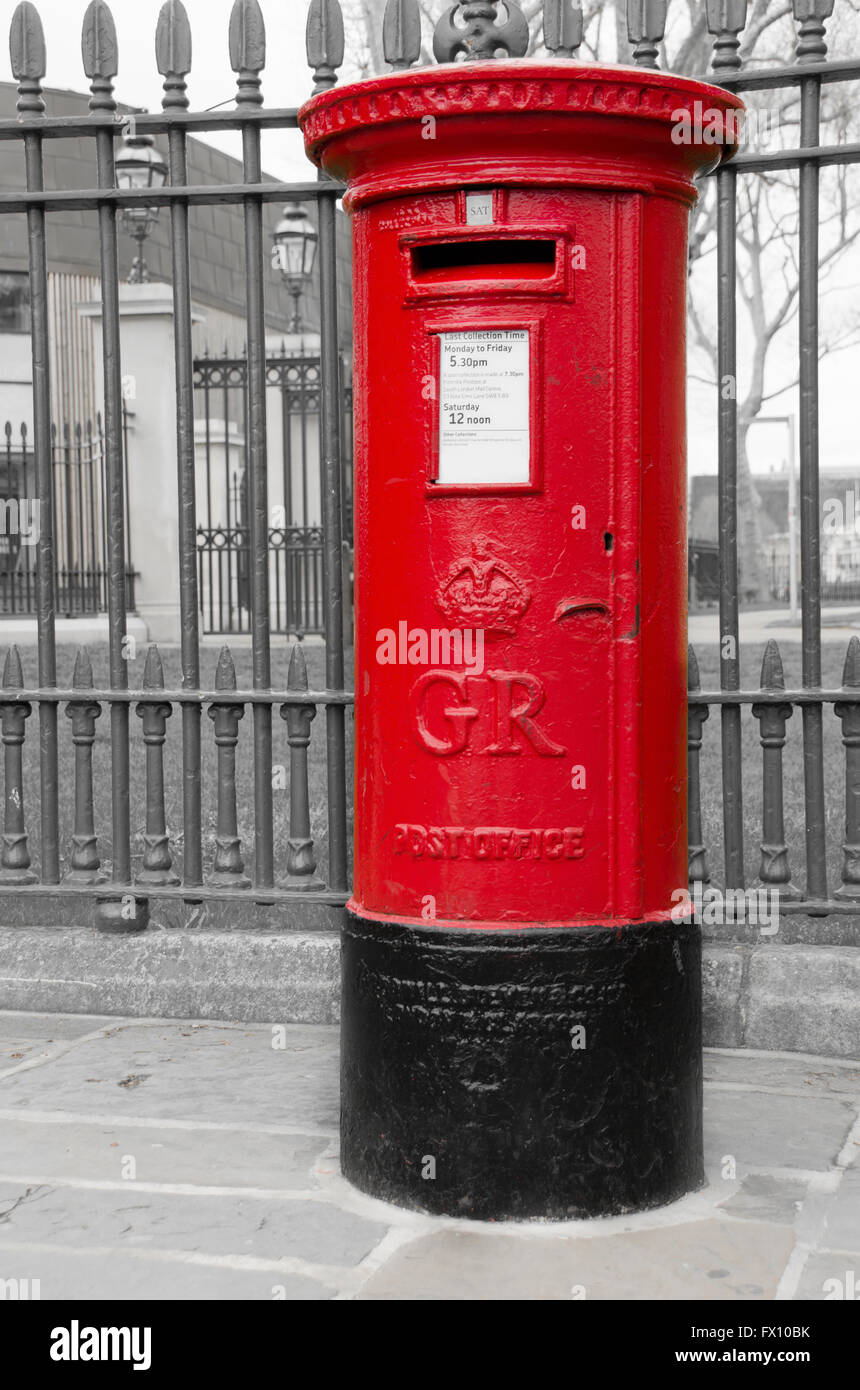 Red uk traditional post box next to the fence Stock Photo - Alamy