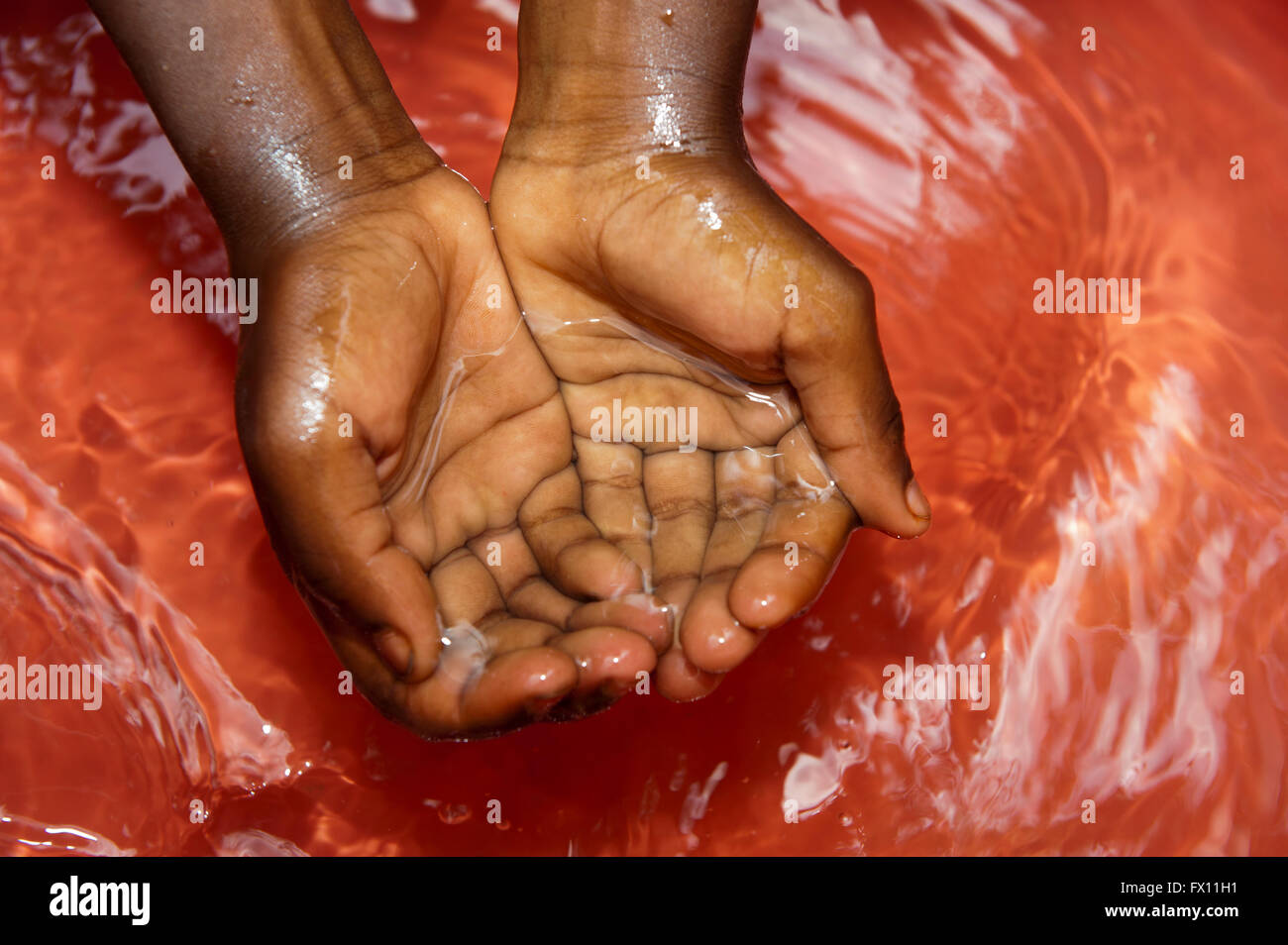 Children washing their hands in fresh, clean water from a well, Rwanda ...