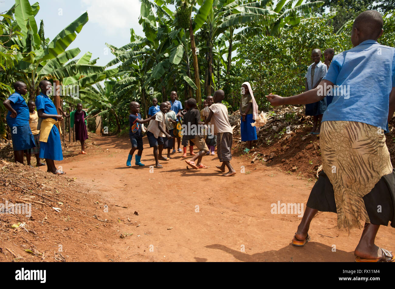 Group of Rwandan children playing a ball game on a dusty road and ...