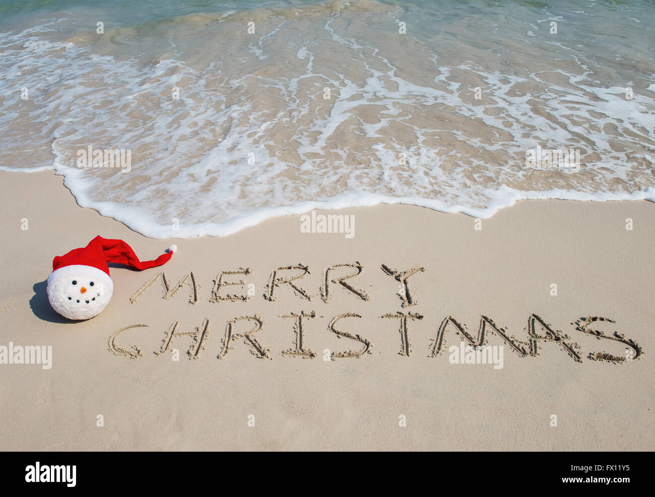 Merry Christmas written on tropical beach white sand with xmas snowman ...