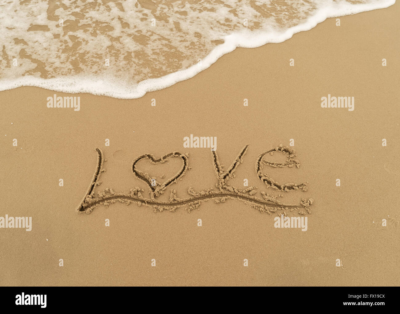 Love write in the sand Stock Photo - Alamy