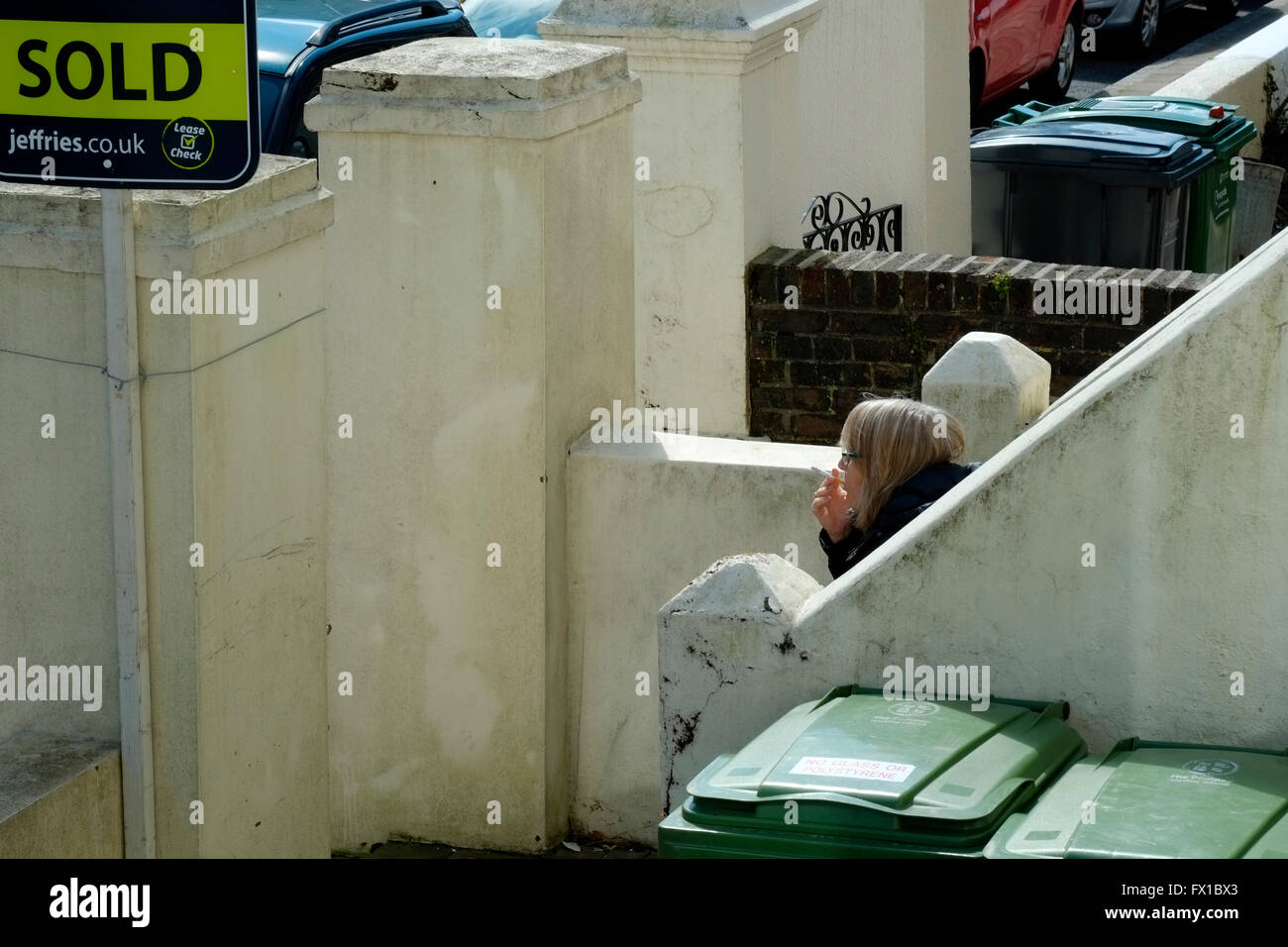 female sat smoking on steps outside of her flat in southsea uk Stock ...