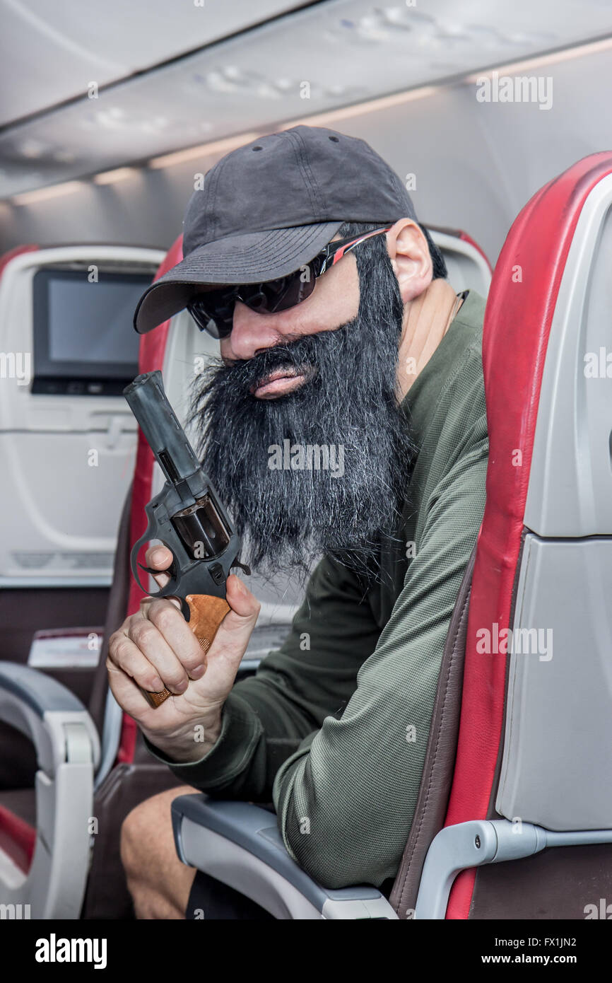 bearded terrorist sitting in a flying aircraft, and holds a pistol in ...