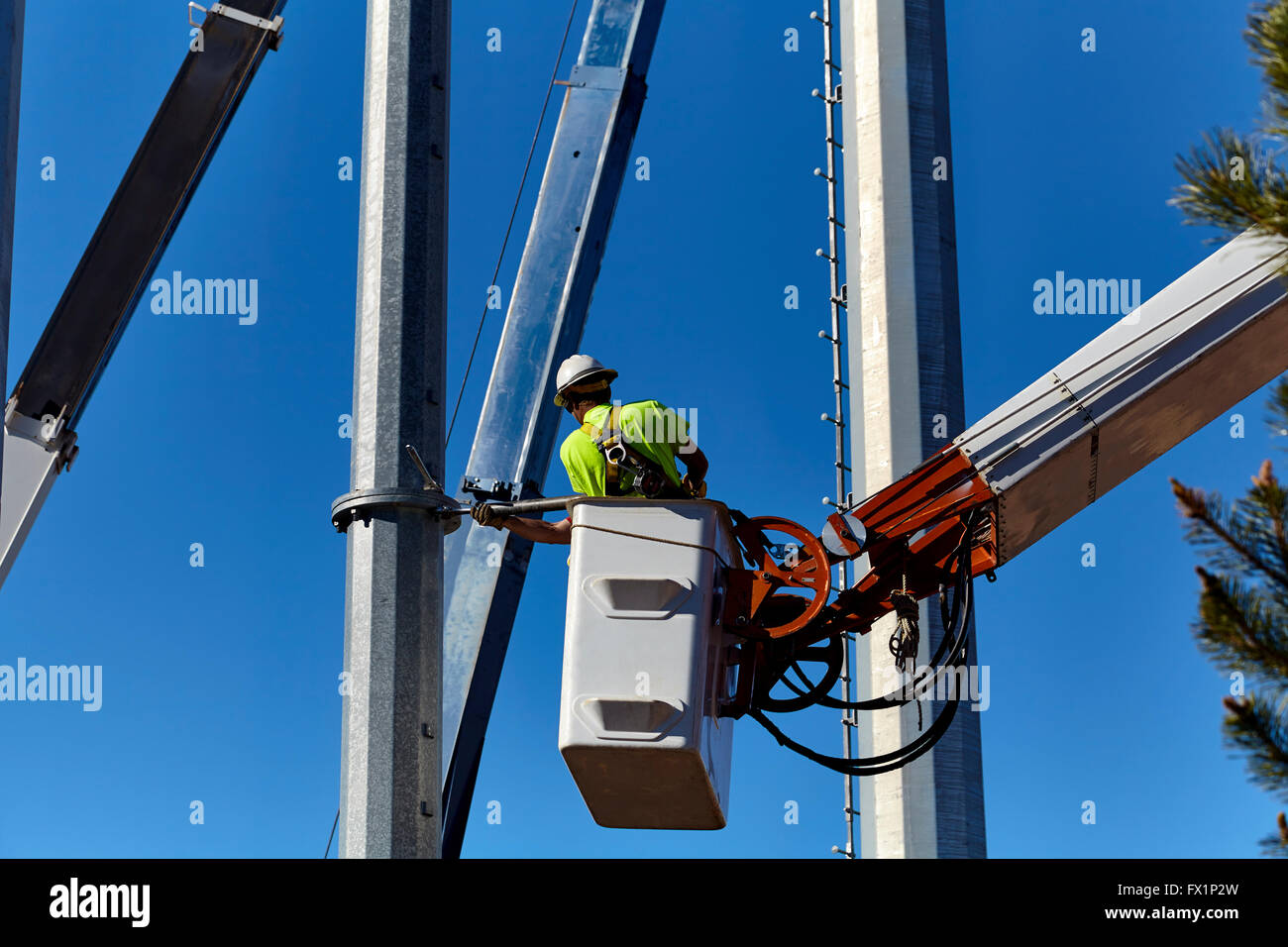 Utility workers in a boom crane basket servicing utility poles Stock ...