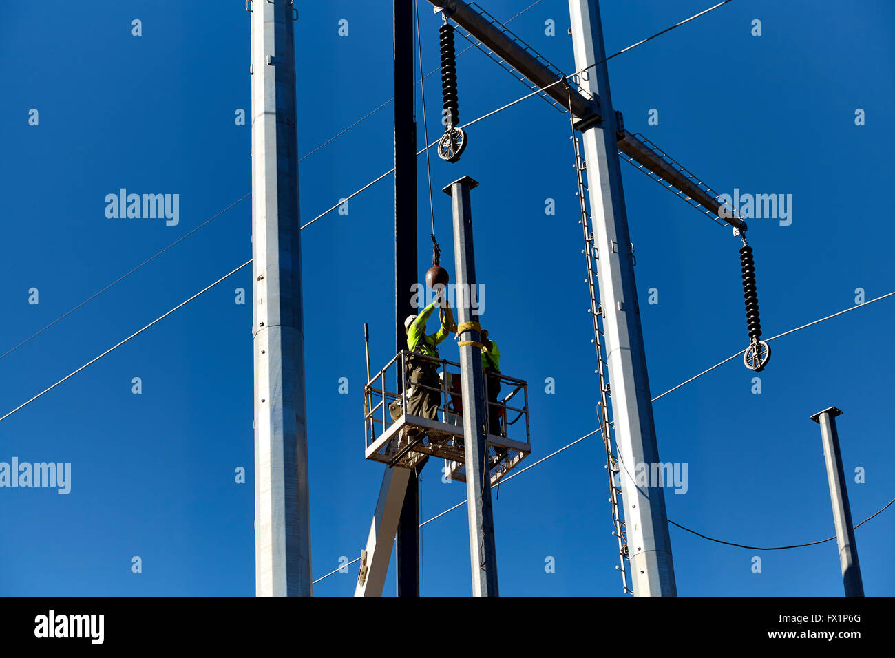 Utility workers in a boom crane basket installing utility poles Stock ...