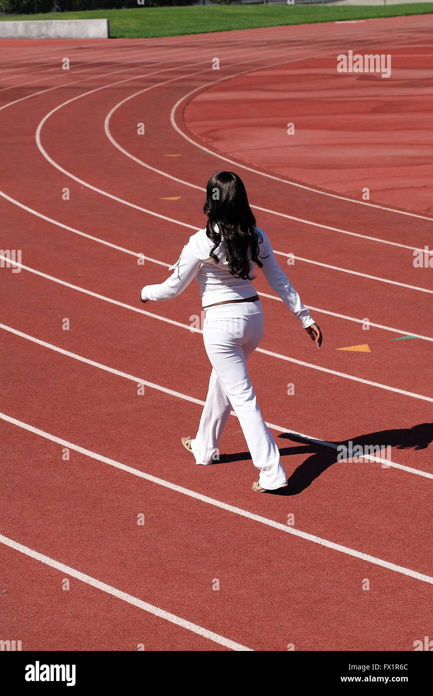 Young African American woman walking for exercise on outdoor track ...