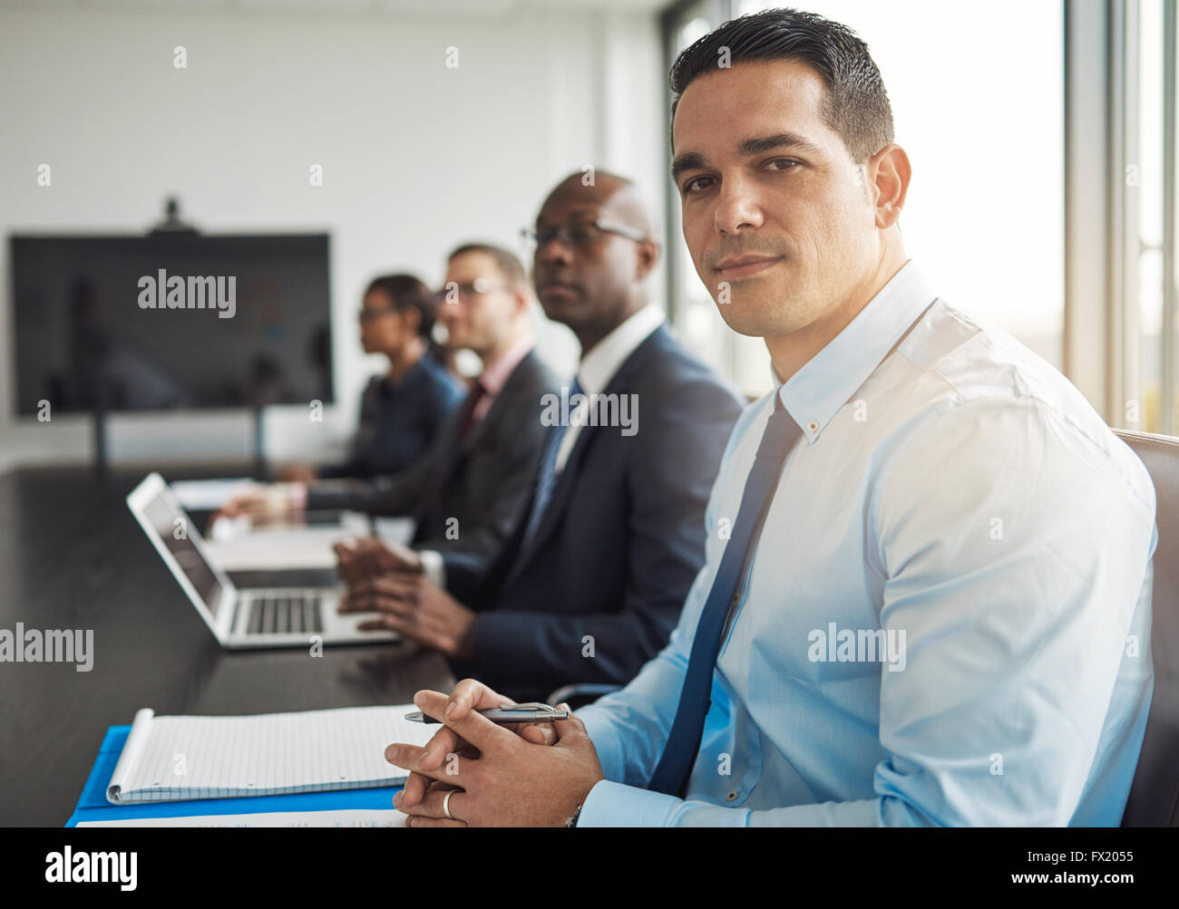 Young Hispanic businessman in a meeting with co-workers at the office ...