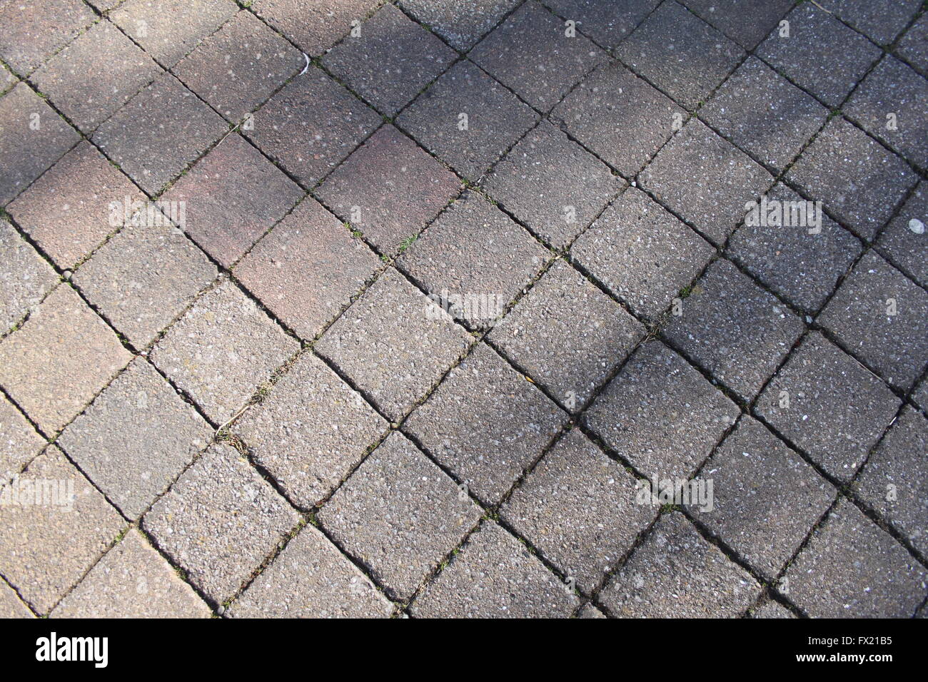 Skewed wide shot of square block paving stones showing shadow and ...