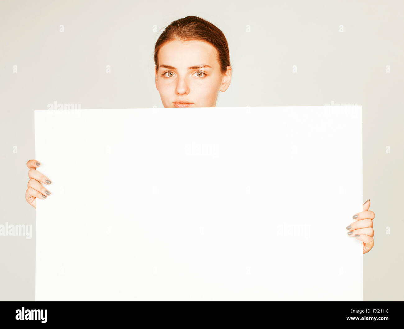 young pretty brunette girl with placard on white background wearing ...