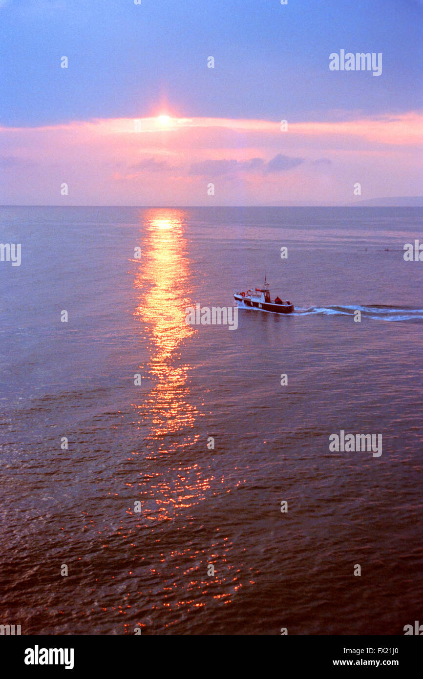 fishing boat sets sail out to sea at dawn in northern france Stock ...