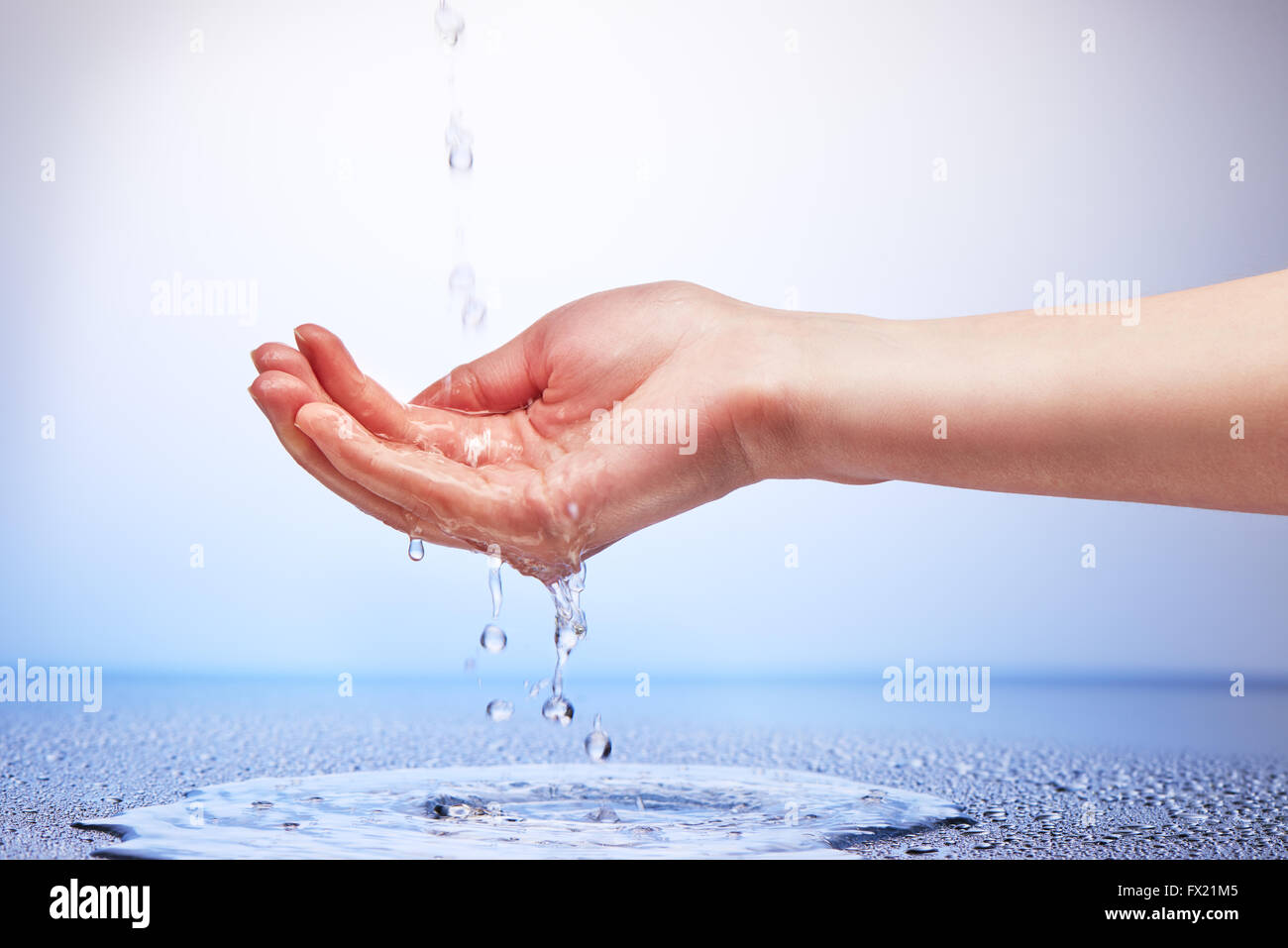 Water falling in women's hand on white and blue background Stock Photo ...