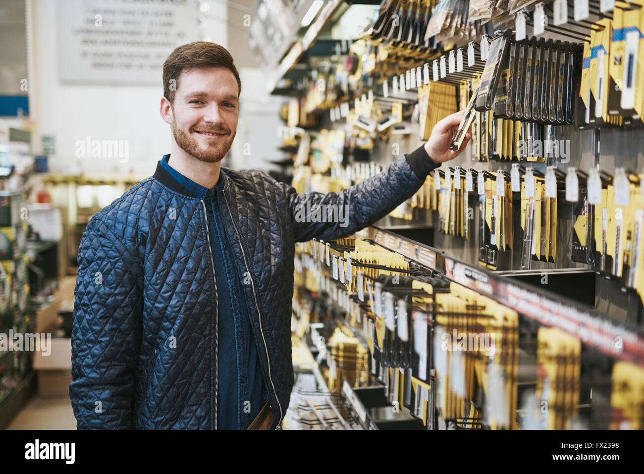 Smiling confident male customer in a hardware store standing smiling at ...