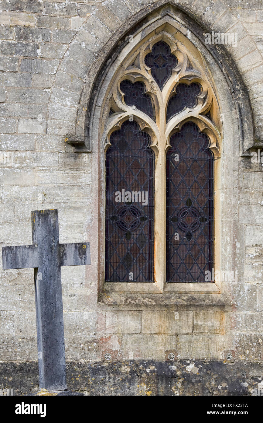 Grave stone next to a arched church window Stock Photo - Alamy