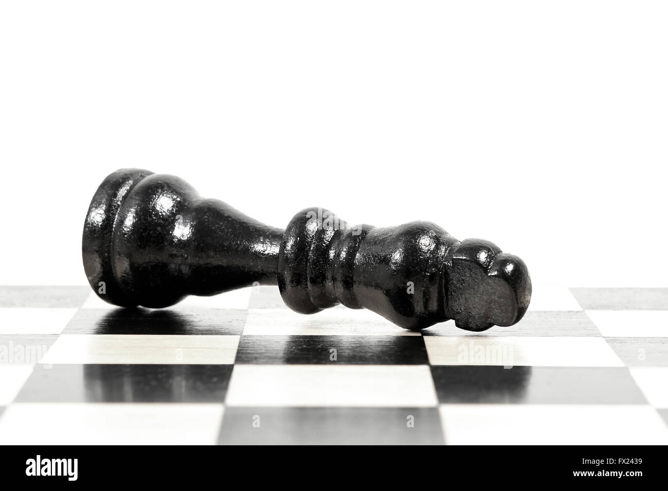 Fallen king in a chess game showing game over Stock Photo - Alamy