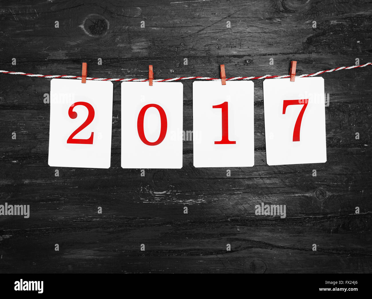 Paper or photo frames with 2017 figures hanging on the red striped rope ...