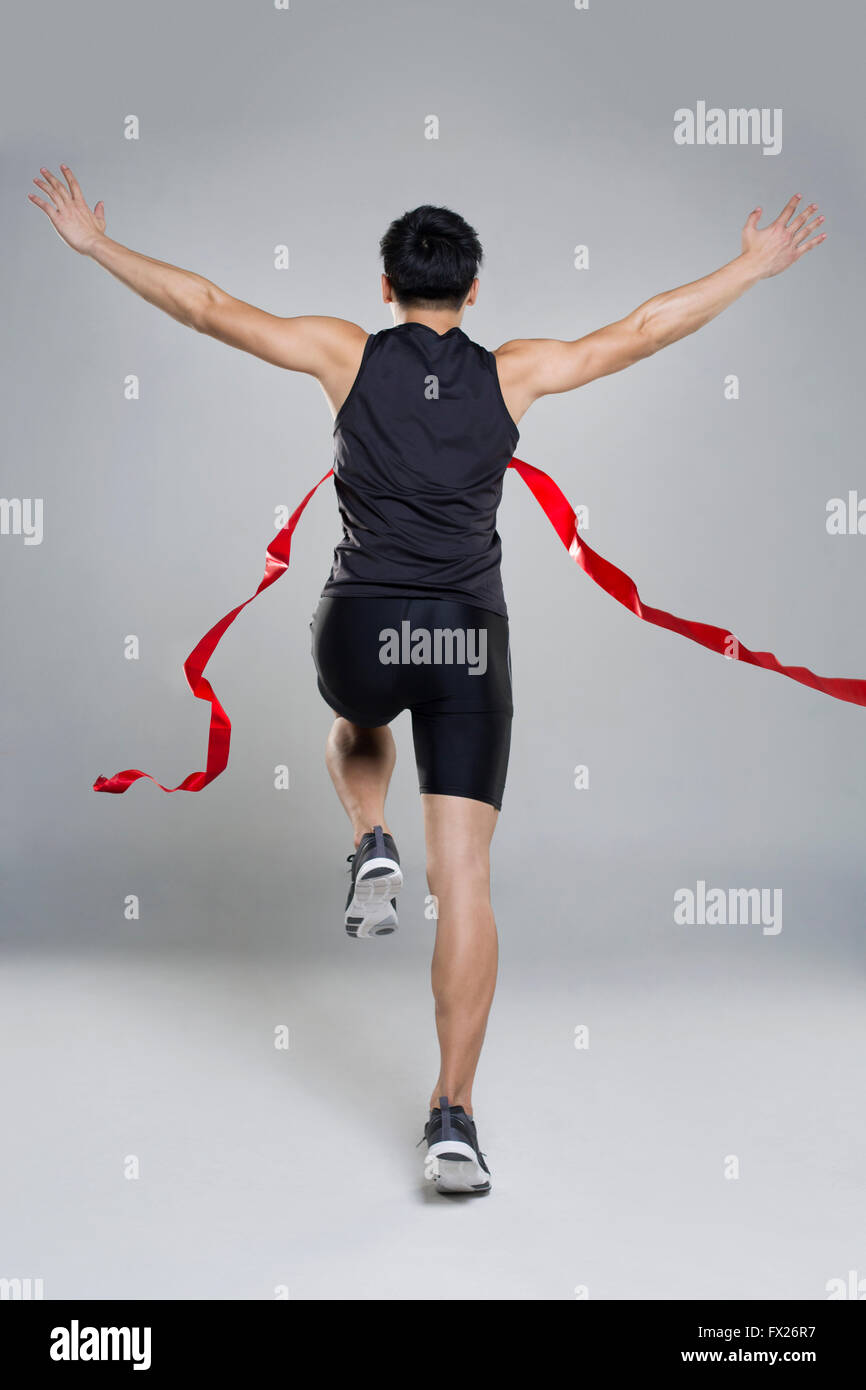 Male athlete reaching the finish line Stock Photo - Alamy