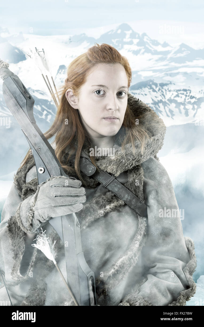 Wild girl archer in the snow with bow Stock Photo - Alamy