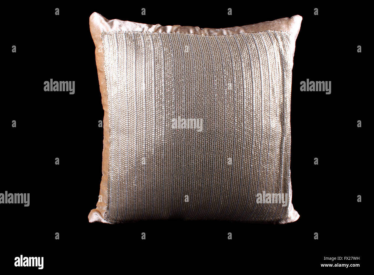 A golden and silver colored shiny pillow with sequins on black studio ...