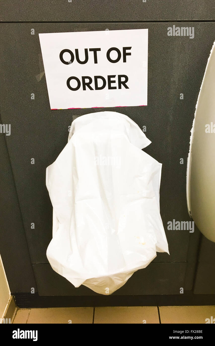 Out of Order sign on gents urinal covered in white plastic bag in ...