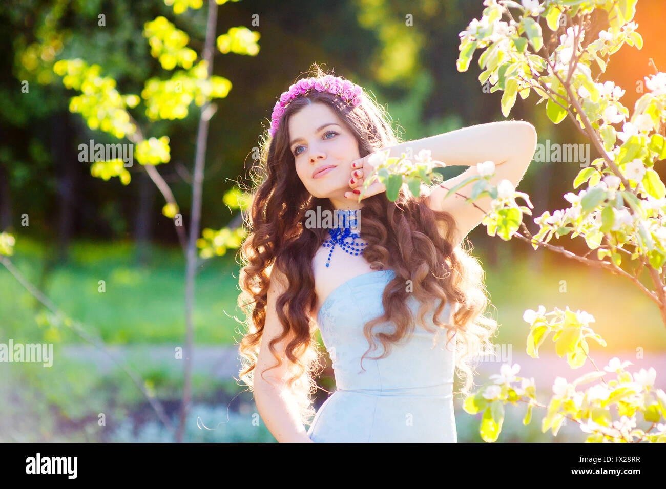 Beautiful young woman in a summer park. Backlit sunlight Stock Photo ...