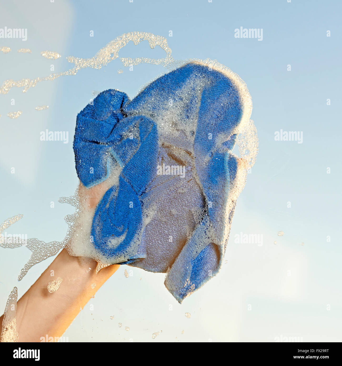 A hand and a blue cloth cleaning windows Stock Photo - Alamy