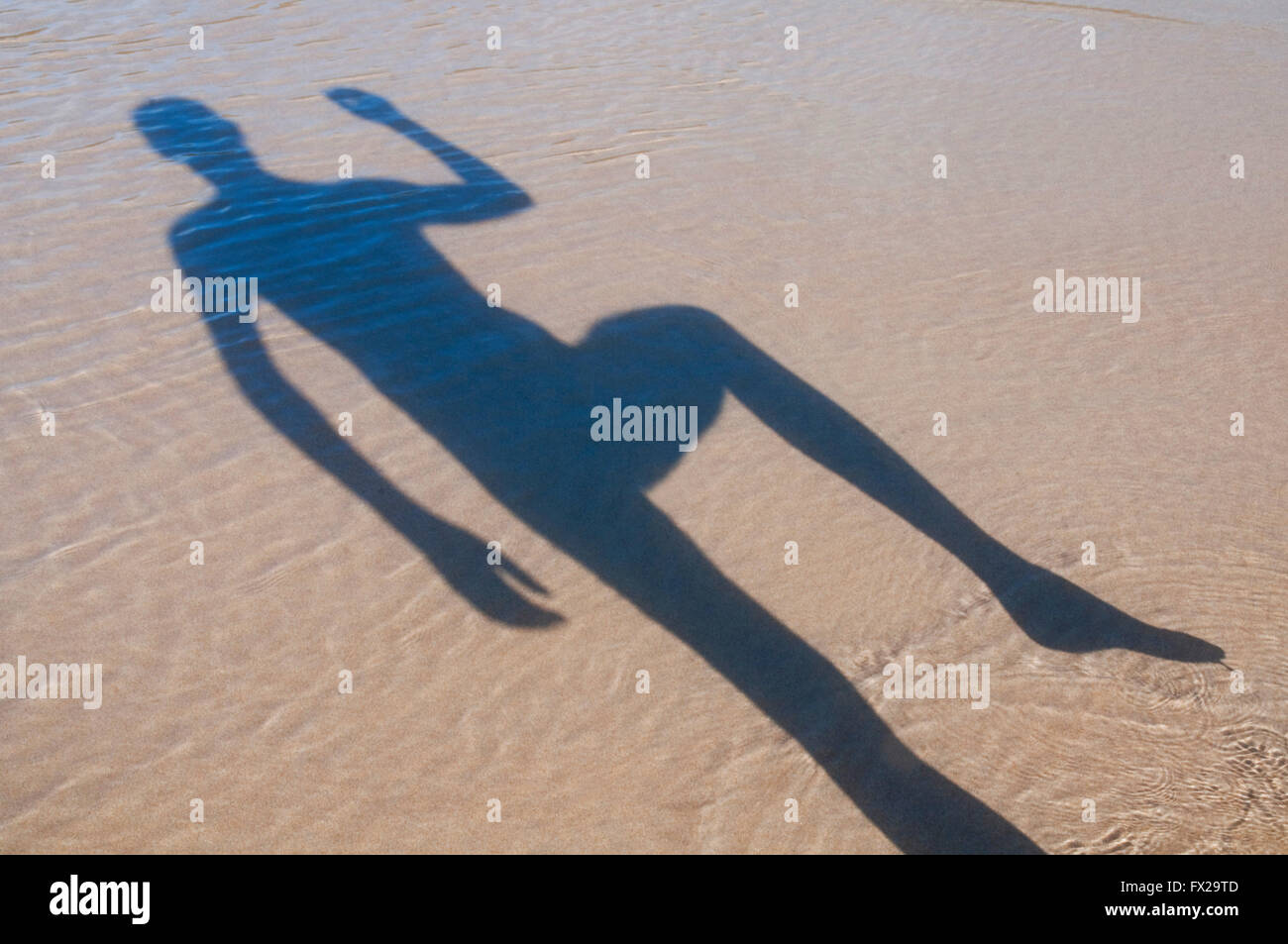 Man's shadow running on the beach Stock Photo - Alamy