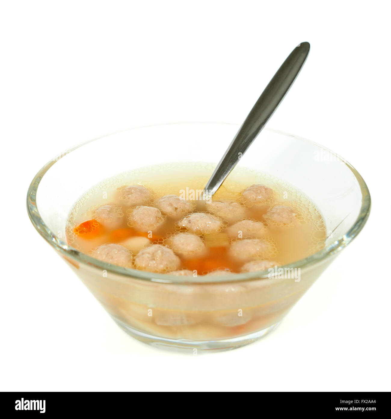 Clear bouillon soup with meatballs and vegetables isolated on white ...