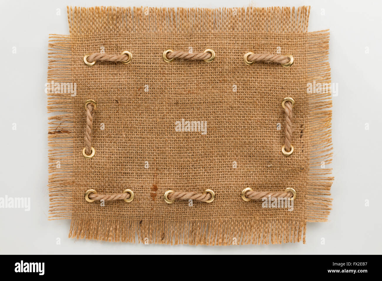 Frame made of burlap with a fringe and rope, on a white background ...