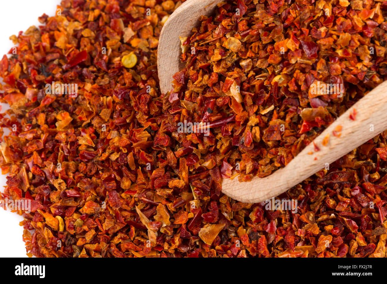 Crushed red chili pepper in spoon on white background Stock Photo - Alamy