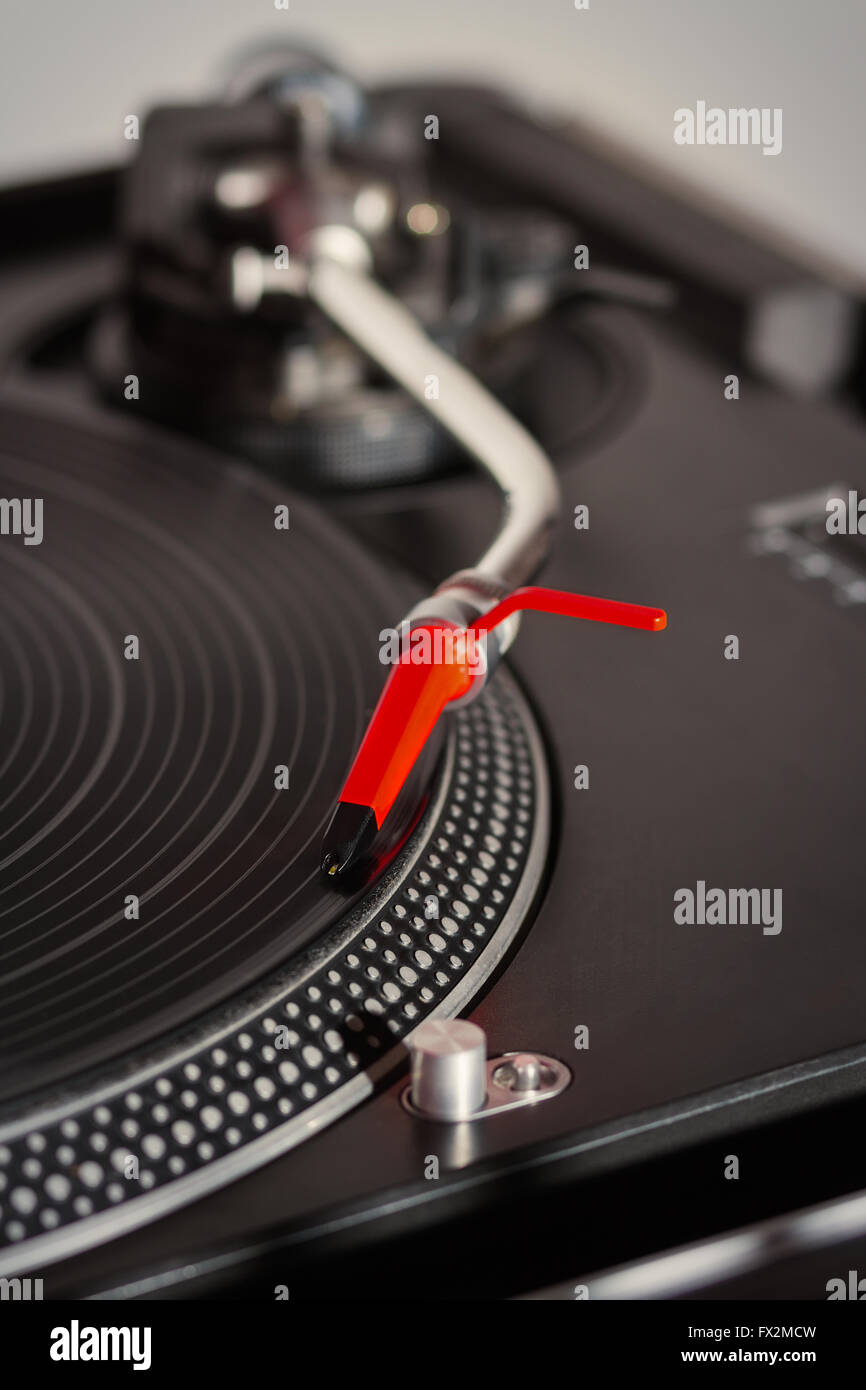 Turntable playing analog audio vinyl disc with music. Close up on ...