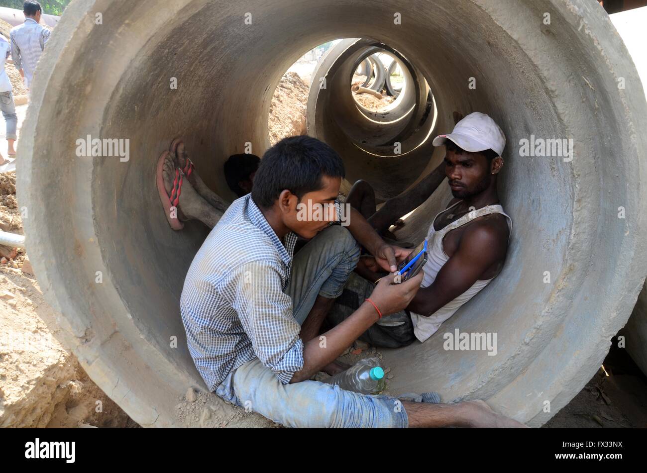 Allahabad, India. 10th Apr, 2016. Labor sleep in a sewage pipe lying ...