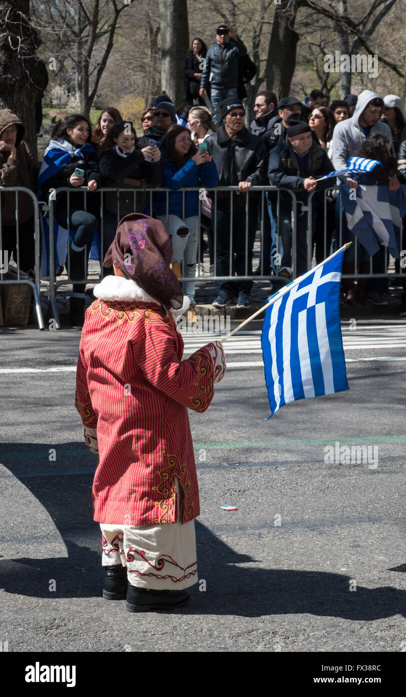 Young child wearing traditional Greek costume and waving a flag in the ...