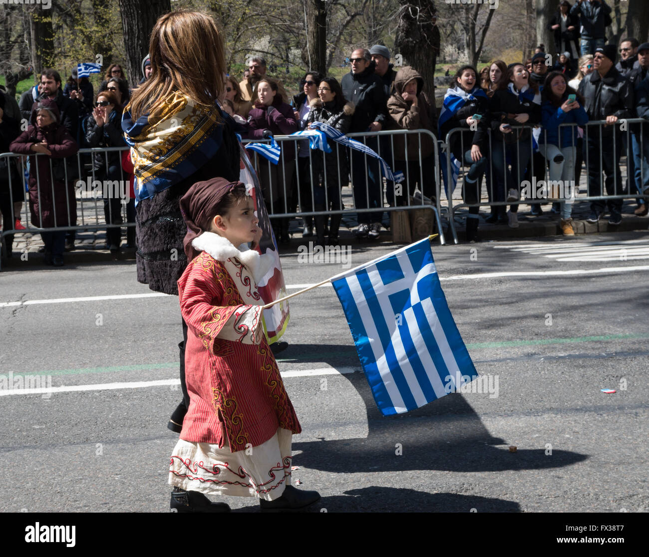 Young child in Greek national dress walking with her mother in the 2016 ...