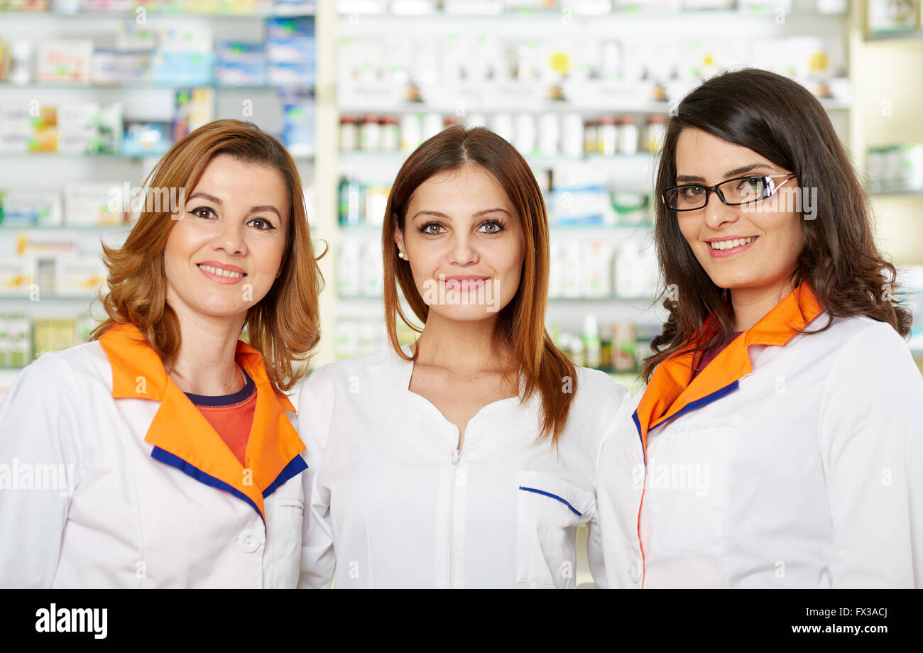 Three pharmacist ladies posing in a pharmacy over blurred background ...
