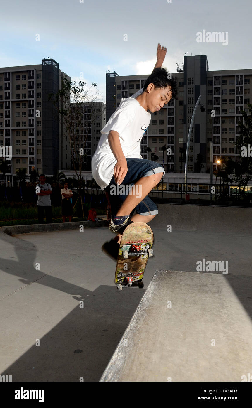 young man playing skateboard in the afternoon at the skate park in ...