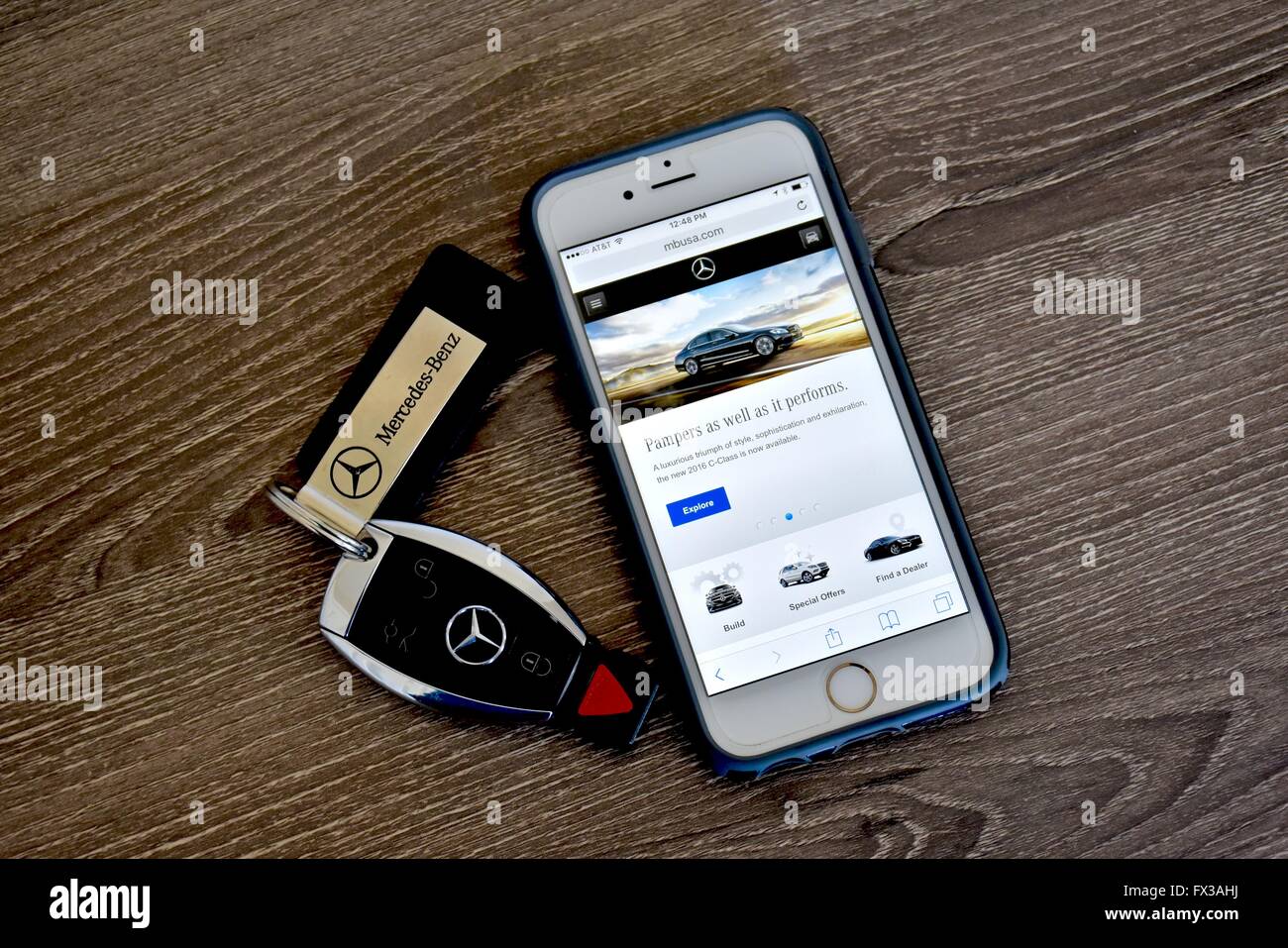 An Apple iPhone displaying the Mercedes-Benz web page while laying next ...