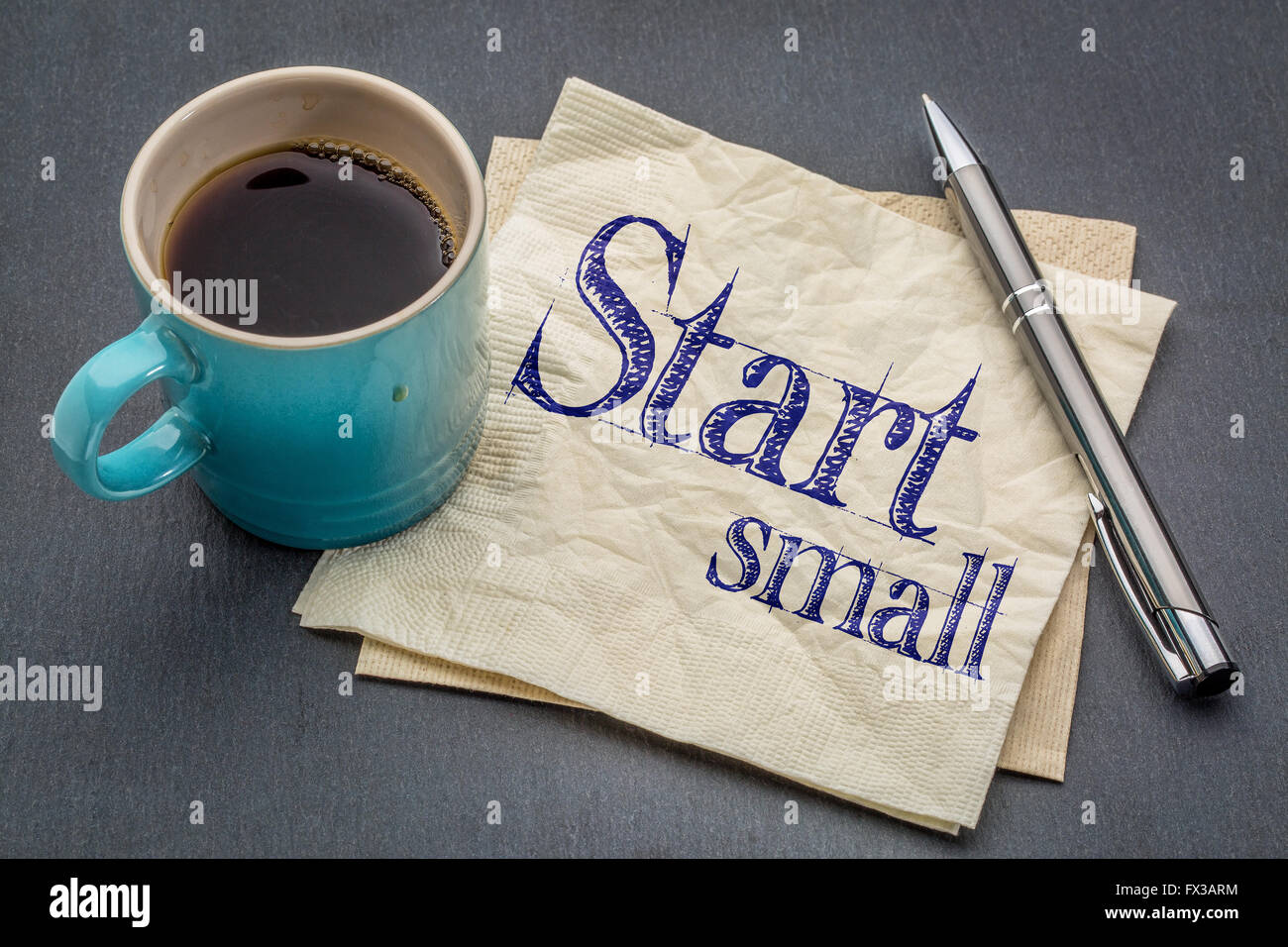 start small advice - handwriting on a napkin with cup of coffee against ...
