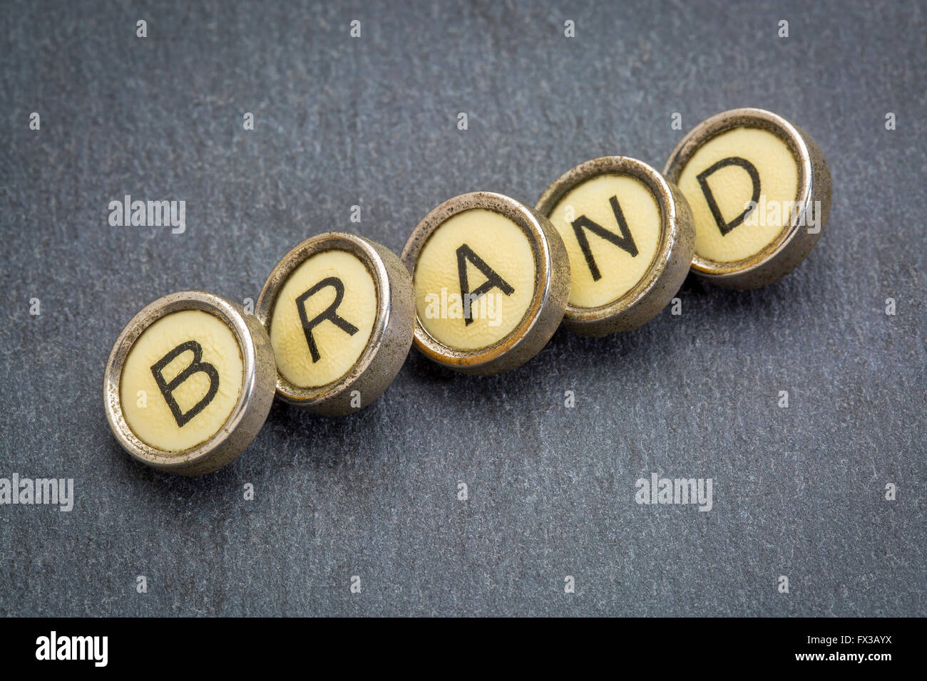 brand word in old round typewriter keys against gray slate stone Stock ...